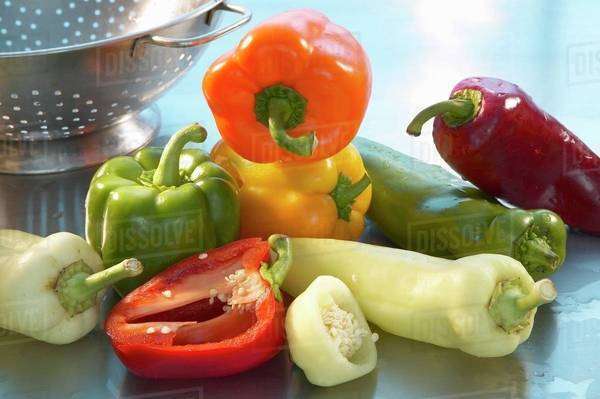 Assorted peppers beside colander - Royalty-free Stock Photo | Dissolve