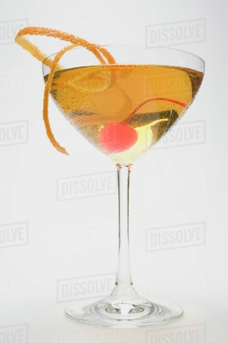 Manhattan with cocktail cherry and orange zest - Stock Photo - Dissolve