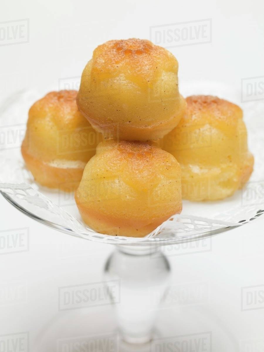 Rum babas on glass cake stand - Royalty-free Stock Photo | Dissolve