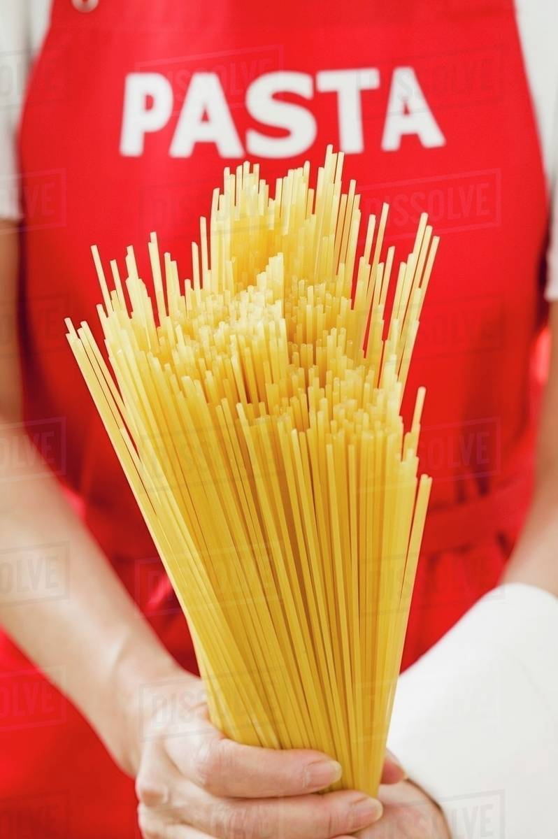 Spaghetti, person with 'pasta' apron in background - Stock Photo - Dissolve