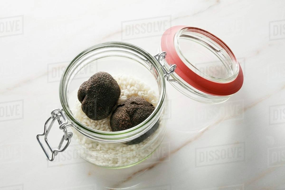 Black truffles and risotto rice in preserving jar - Stock Photo - Dissolve