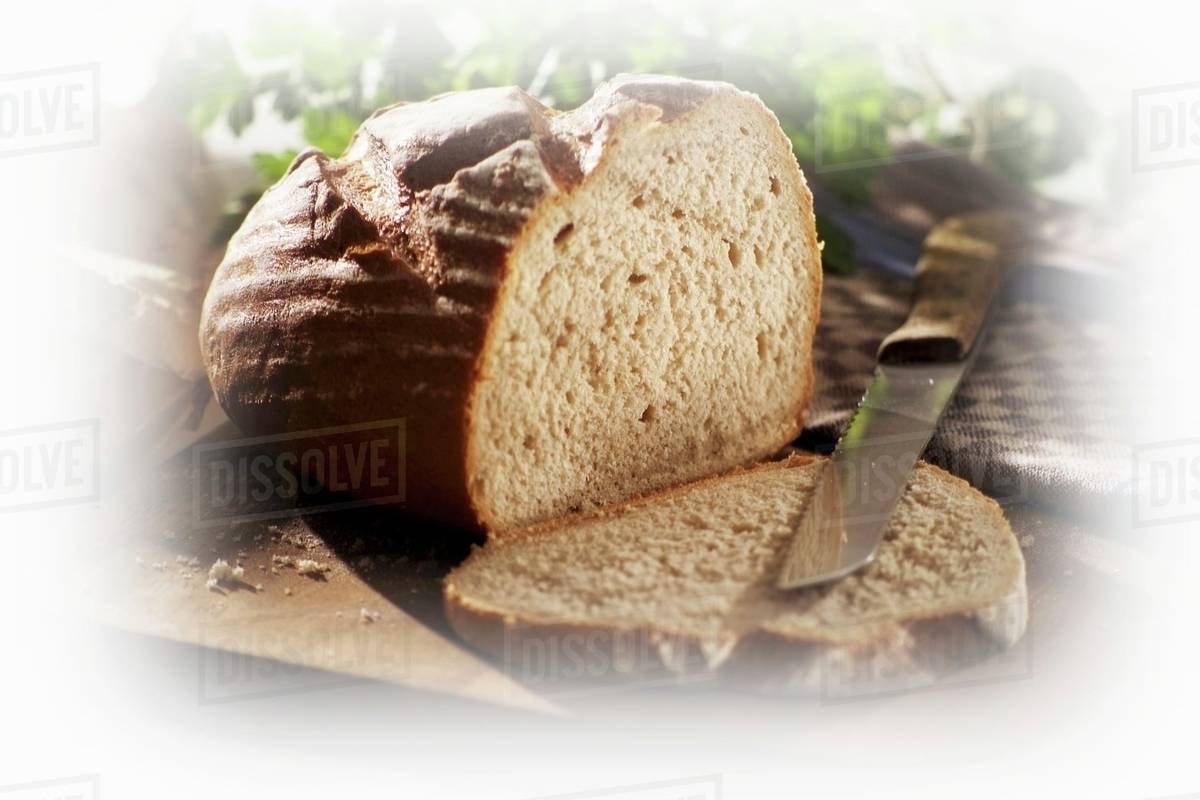 Crusty bread, partly sliced - Stock Photo - Dissolve