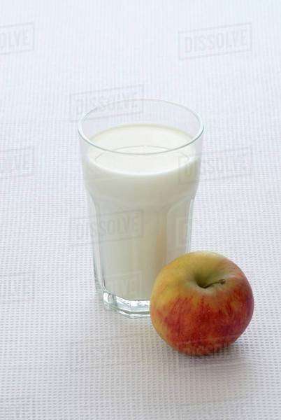 A glass of milk and an apple - Stock Photo - Dissolve