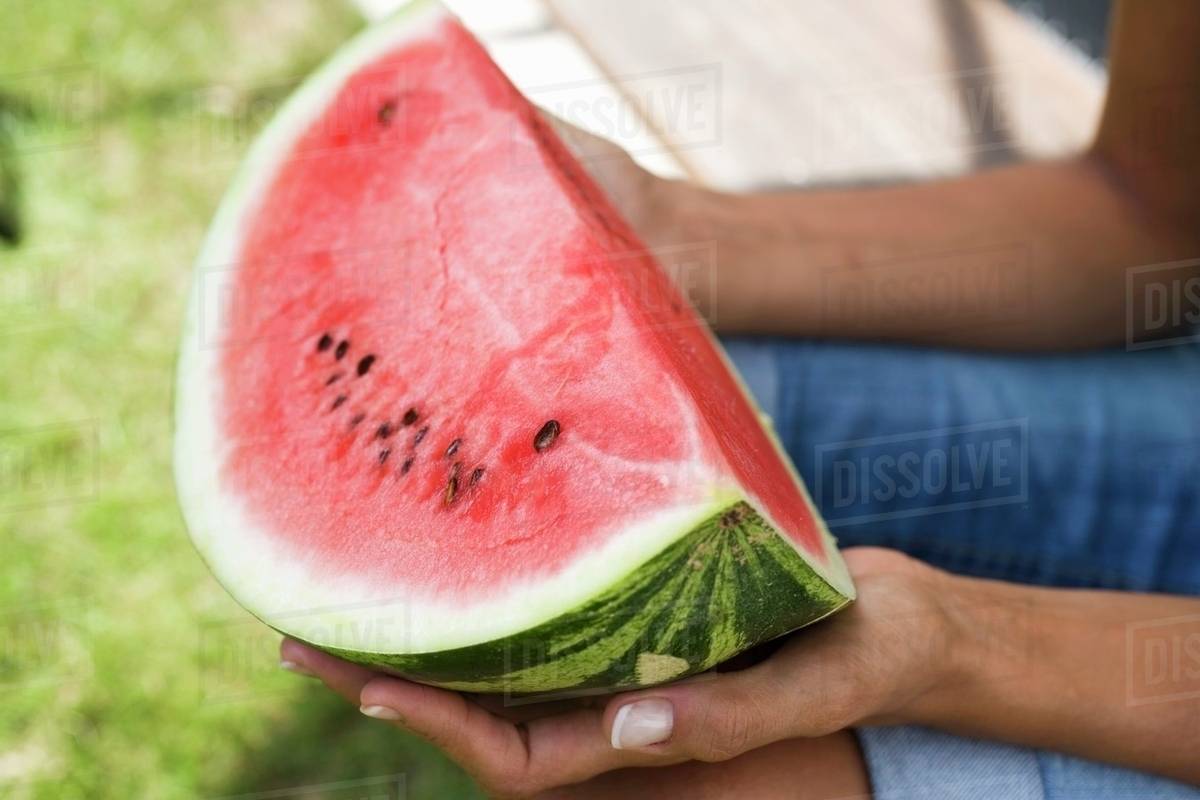 Hands holding a slice of watermelon - Royalty-free Stock Photo | Dissolve