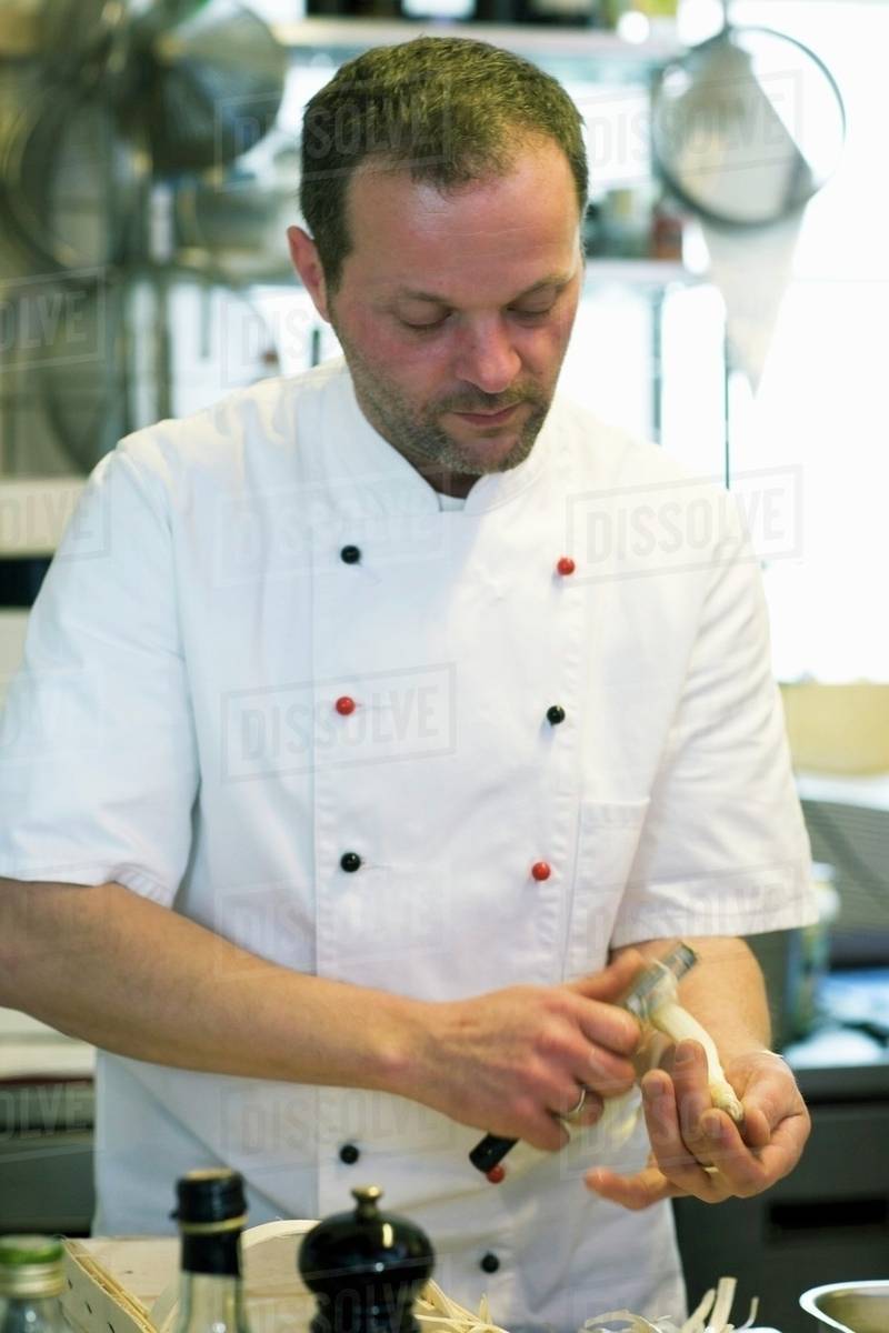 Chef peeling asparagus - Royalty-free Stock Photo | Dissolve