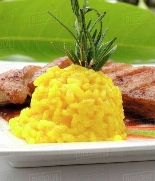 Saffron risotto served with roast duck breast - Stock Photo - Dissolve