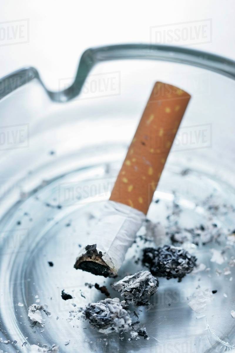 Cigarette end in an ashtray - Stock Photo - Dissolve