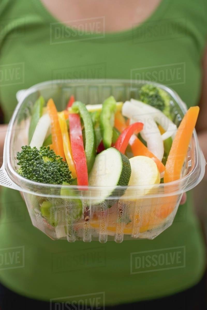 Woman holding plastic container of sliced vegetables - Royalty-free ...