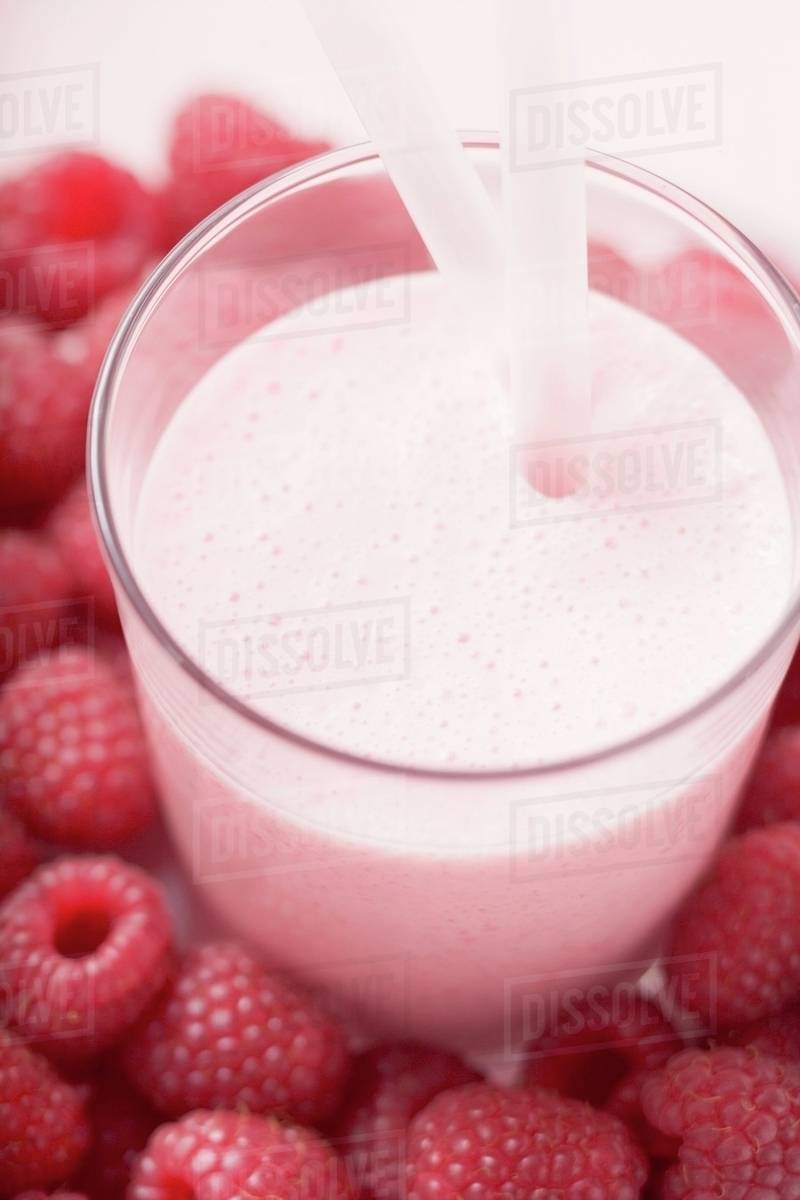 Raspberry shake in glass, surrounded by fresh raspberries - Royalty ...