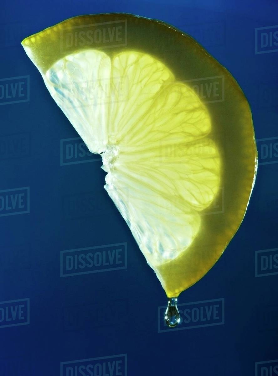 Lemon juice dripping from a slice of lemon - Royalty-free Stock Photo ...