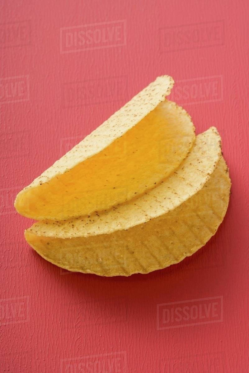 Two taco shells on red background - Stock Photo - Dissolve