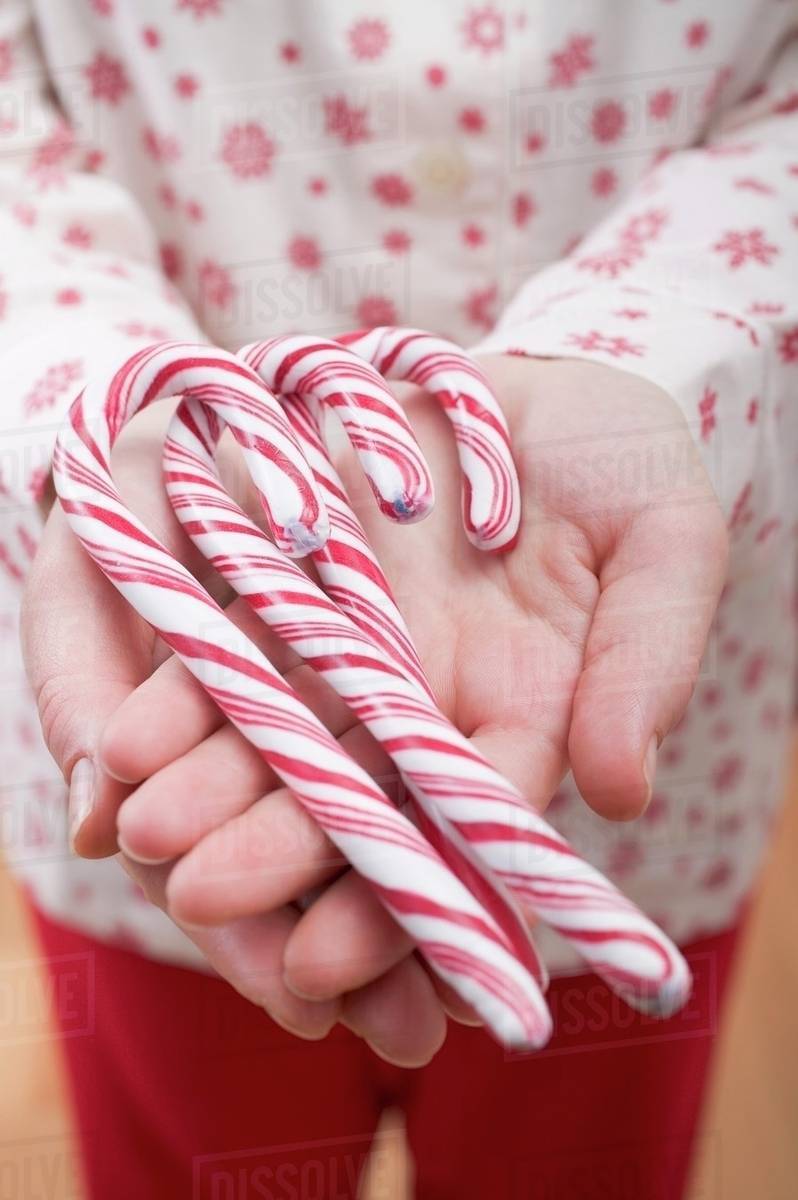 Woman holding candy canes - Stock Photo - Dissolve