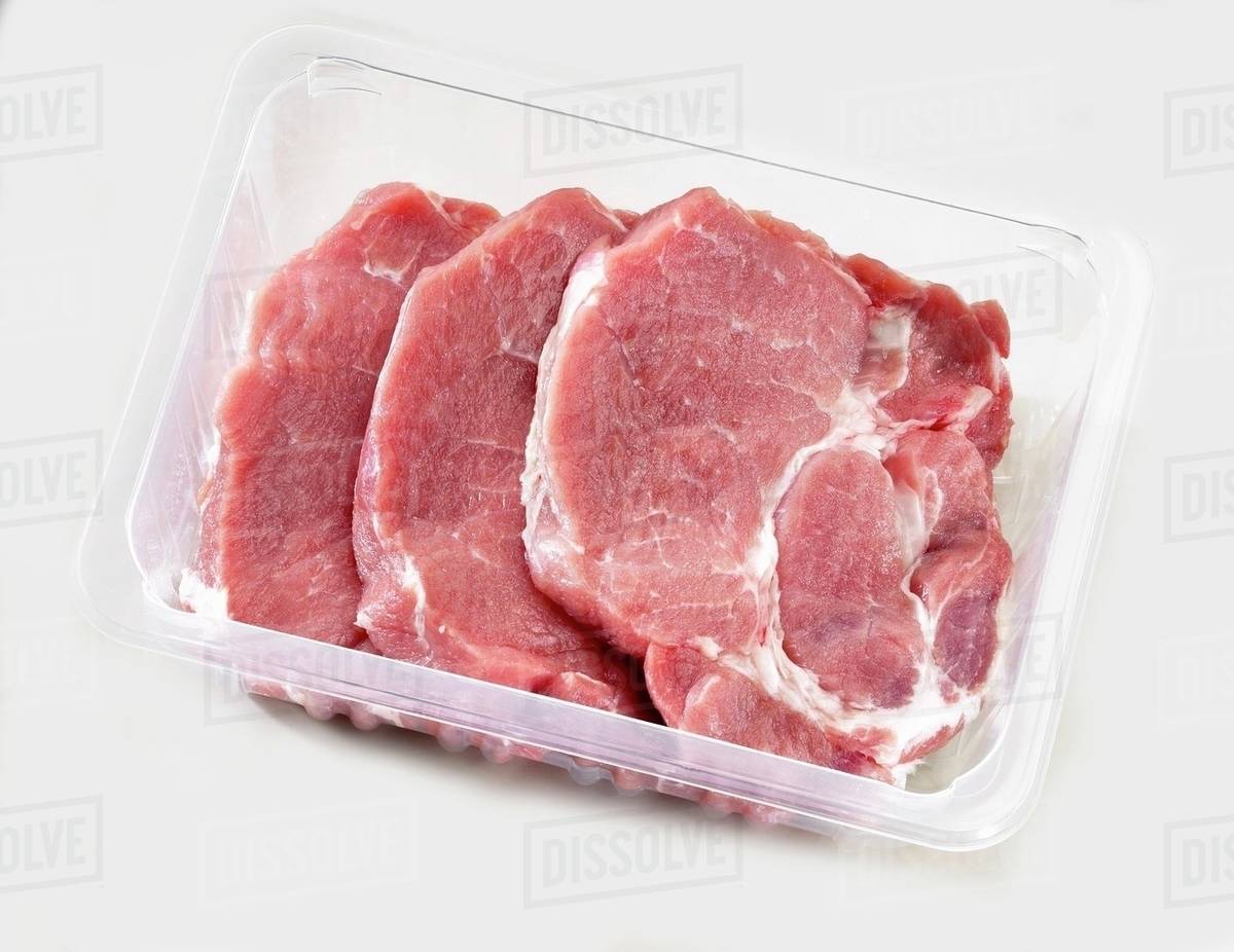 Pork neck steaks in plastic container - Royalty-free Stock Photo | Dissolve