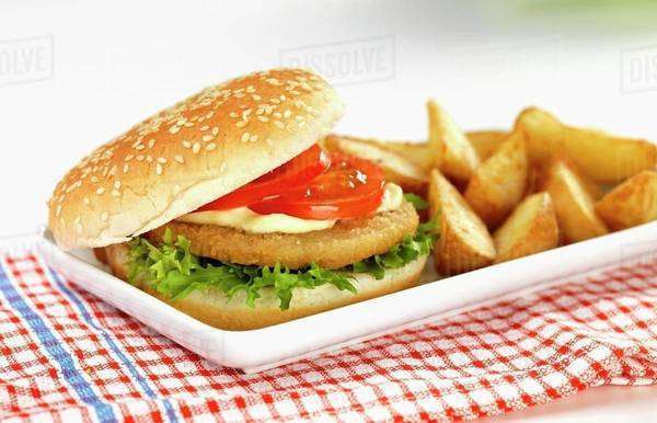 A chicken burger with potato wedges - Royalty-free Stock Photo | Dissolve