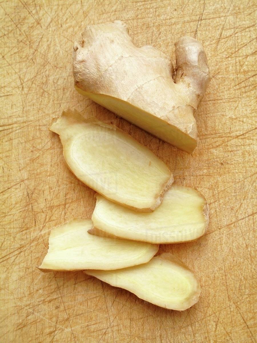 Fresh ginger, sliced, on a chopping board - Royalty-free Stock Photo ...