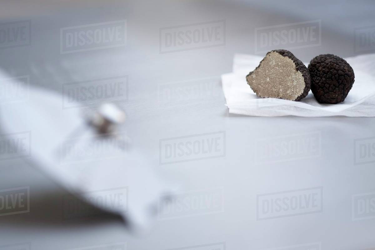 Black truffles, halved, on paper, on a truffle slice - Royalty-free ...