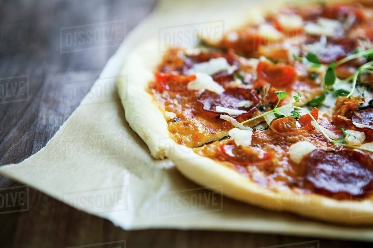 A pepperoni pizza with grated Parmesan (detail) - Stock Photo - Dissolve