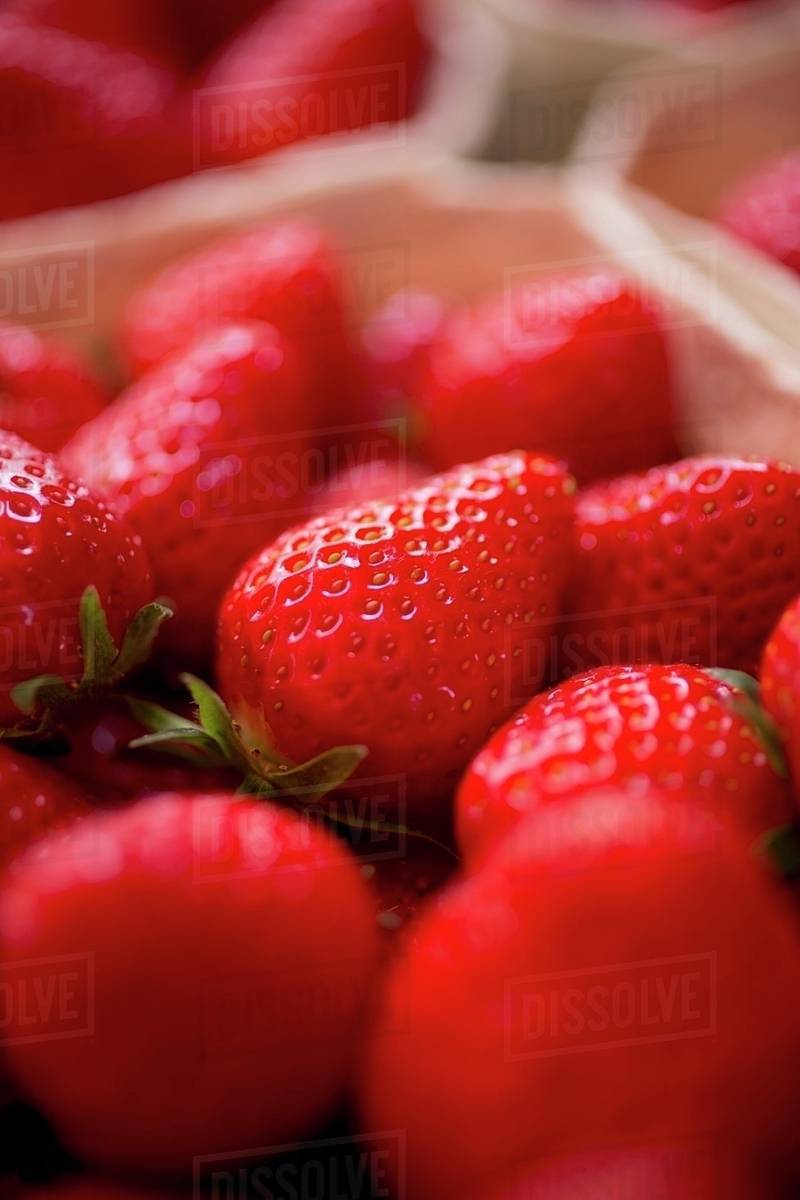 Fresh strawberries in a paper punnet (close-up) - Stock Photo - Dissolve