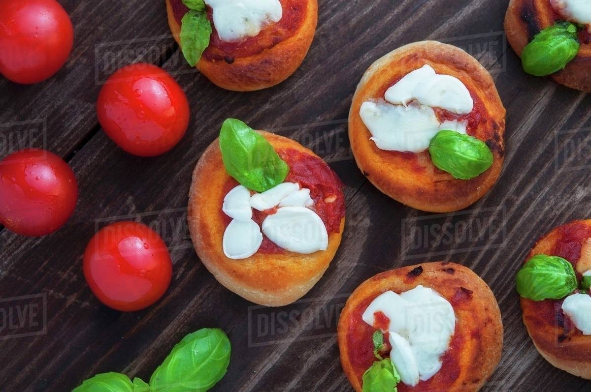 Pizzette (mini pizzas with tomatoes, mozzarella and basil) - Stock ...