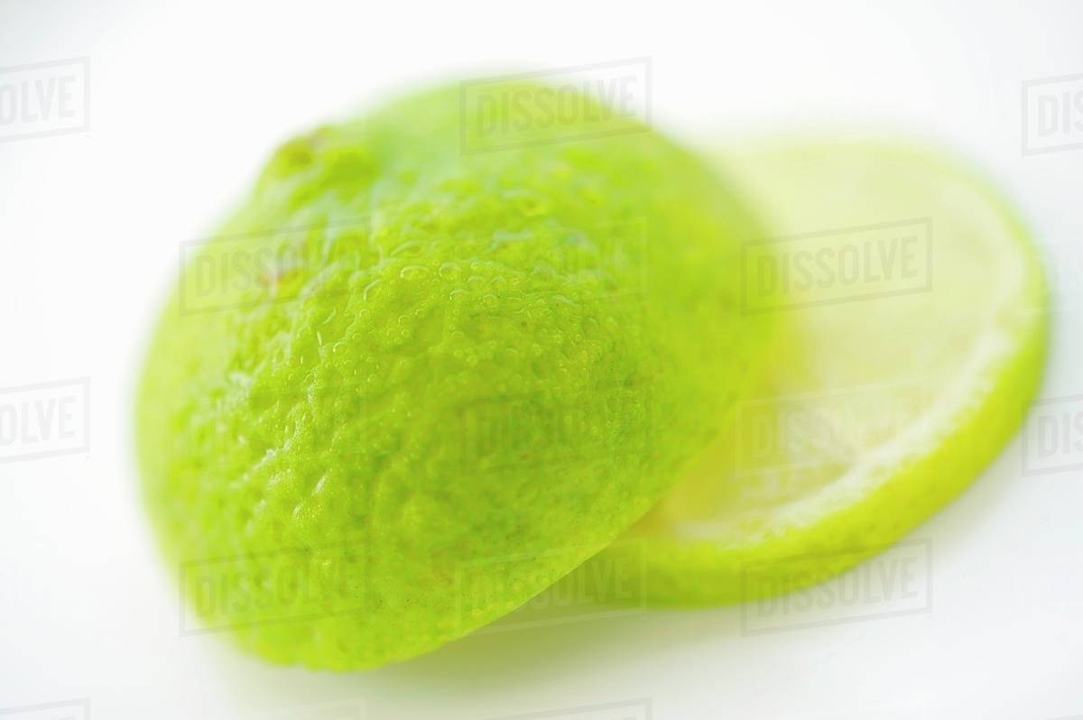 Half a lime and a slice of lime - Stock Photo - Dissolve