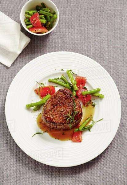 Bison fillet steak with a bean and tomato medley - Stock Photo - Dissolve