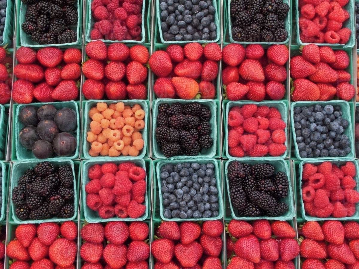 Various berries and figs in cardboard punnets at a market - Royalty ...