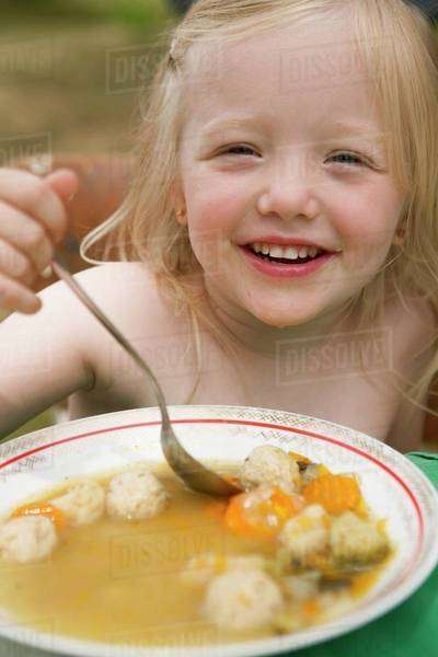 A little girl eating vegetable soup with yeast dumplings - Royalty-free ...