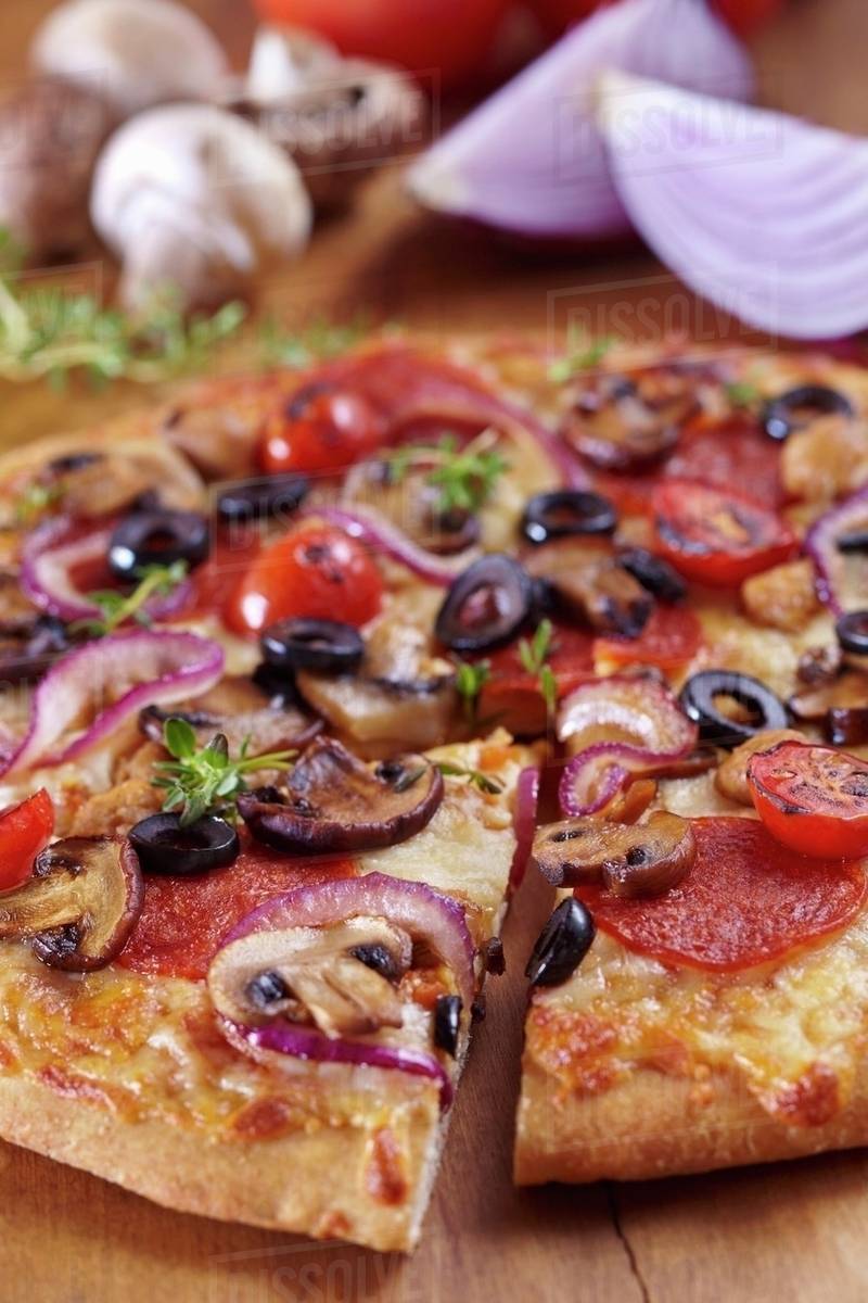 Loaded Pizza with a Slice Partially Removed - Royalty-free Stock Photo ...