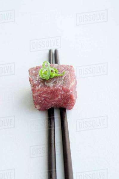 Wagyu beef on chopsticks with sliced spring onions (Negi) - Stock Photo ...
