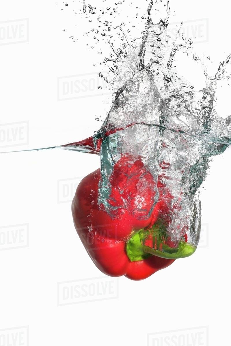 A red pepper falling into water - Royalty-free Stock Photo | Dissolve