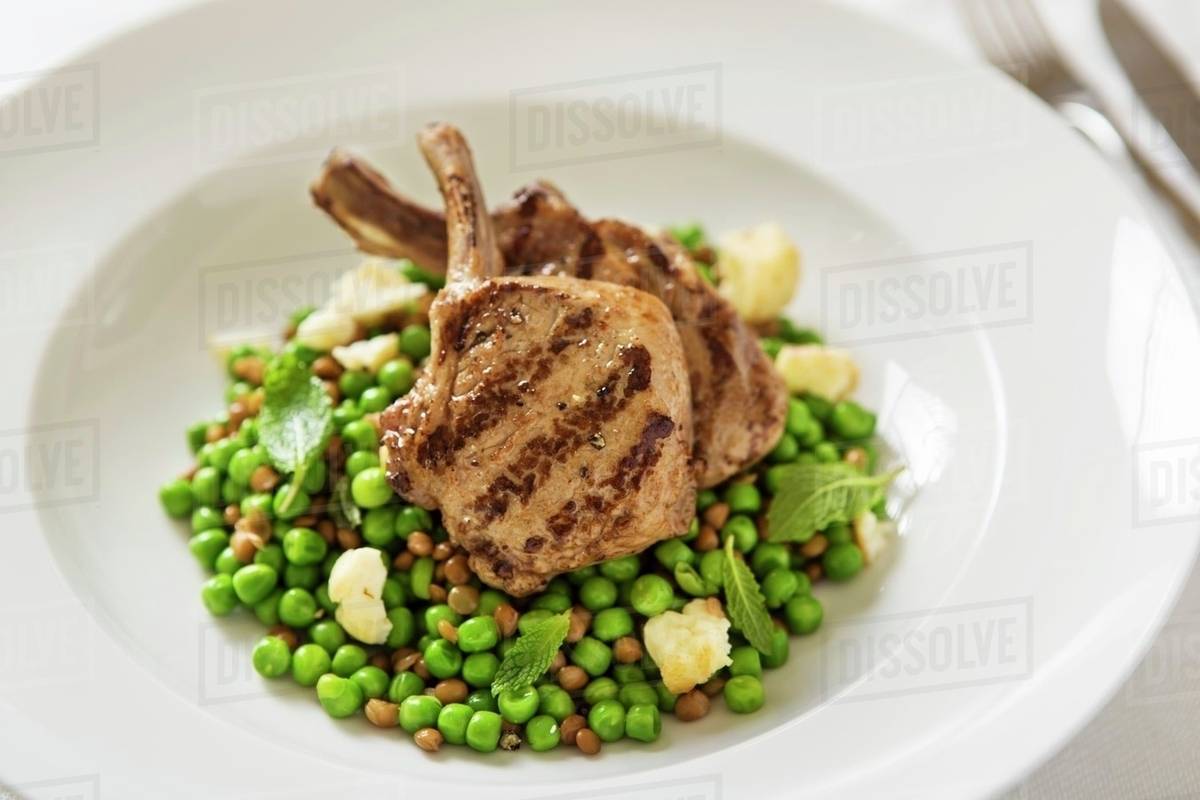 Grilled lamb chops on peas - Royalty-free Stock Photo | Dissolve