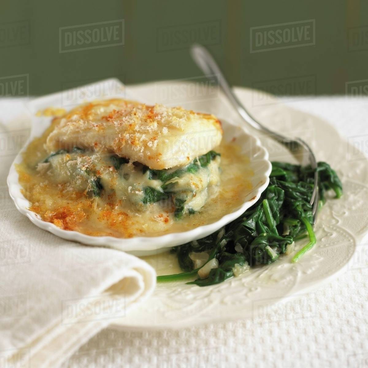 Haddock baked with cheese, served with spinach - Royalty-free Stock ...