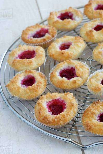 Coconut macaroons with raspberry jam on a wire rack - Stock Photo ...