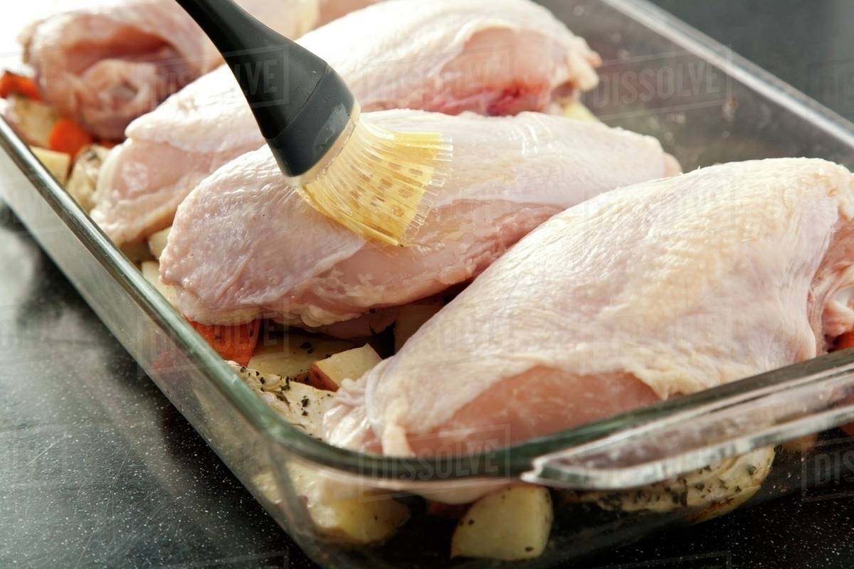 Basting Chicken Breast in a Roasting Dish - Stock Photo - Dissolve