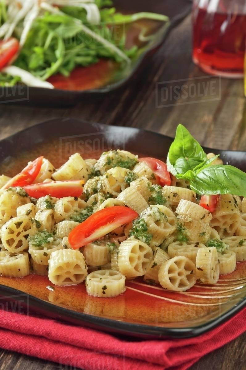 Wagon Wheel Pasta with Homemade Pesto Sauce and Tomatoes - Royalty-free ...