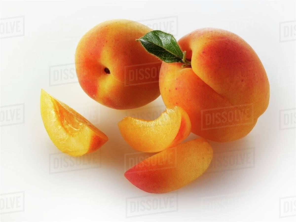 Two whole apricots and apricot slices - Royalty-free Stock Photo | Dissolve