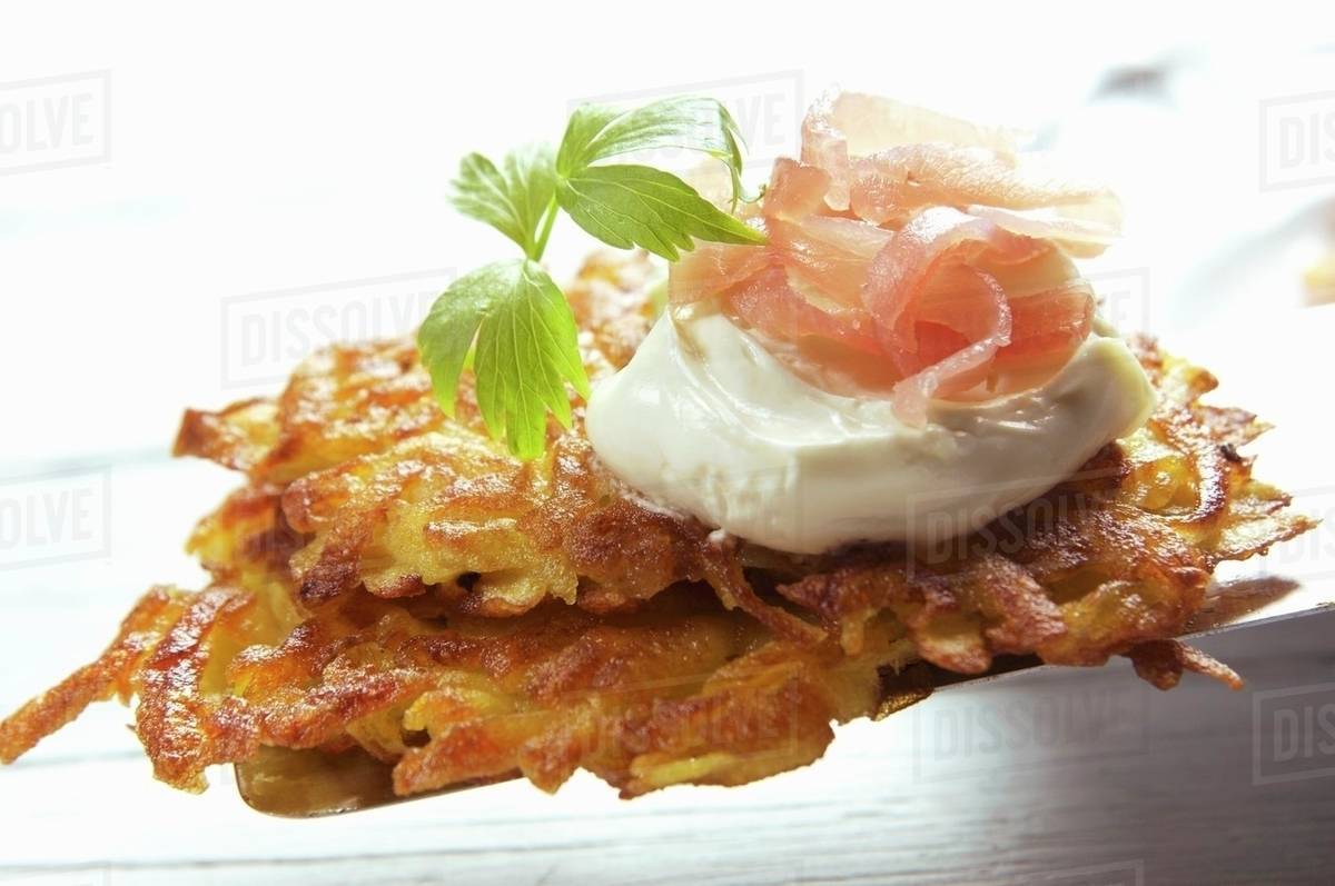 Potato rosti (hash brown) with sour cream and smoked ham - Royalty-free ...