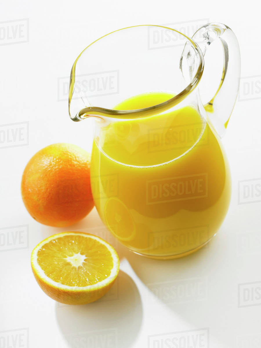 Orange juice in glass jug; fresh oranges - Royalty-free Stock Photo ...