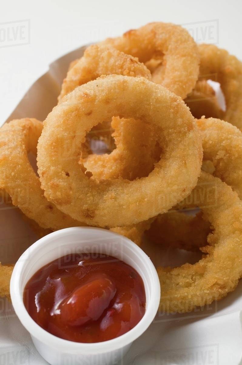 Squid rings in paper dish with dip - Royalty-free Stock Photo | Dissolve