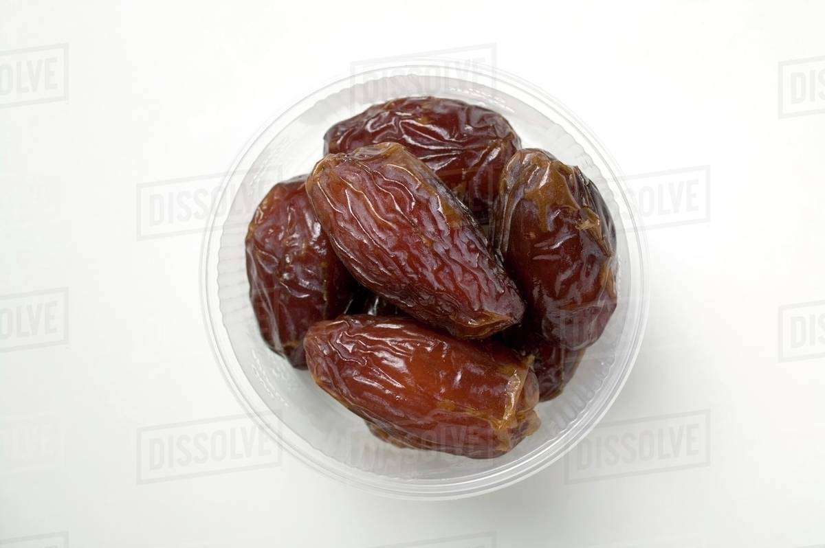 Dried dates in plastic dish - Stock Photo - Dissolve