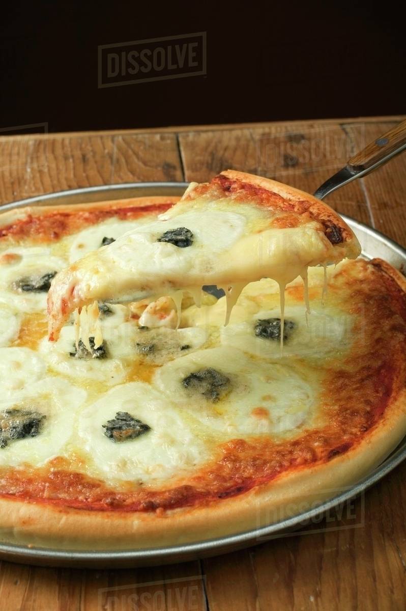 American-style three cheese pizza with piece on server - Royalty-free ...