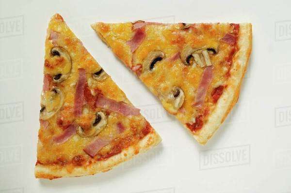 Slices of American-style ham and mushroom pizza - Stock Photo - Dissolve