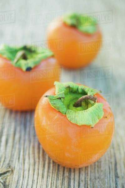Three Sharon fruits on wooden background - Royalty-free Stock Photo ...