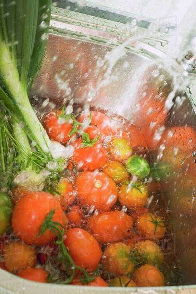 Washing tomatoes and spring onions - Stock Photo - Dissolve