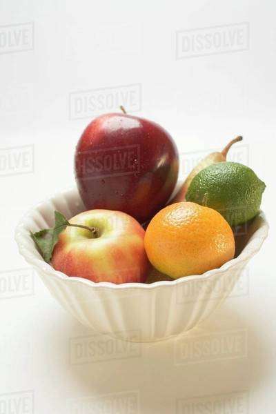Core fruit and citrus fruit in white bowl - Stock Photo - Dissolve