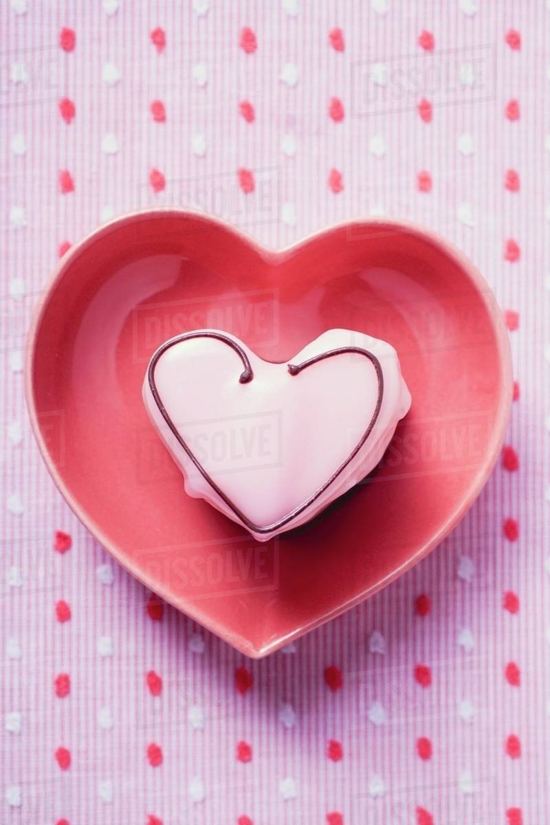 Pink heart-shaped petit four in pink heart-shaped dish - Royalty-free ...