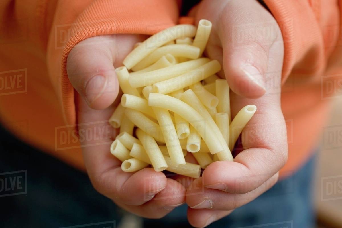 Child's hands holding macaroni - Royalty-free Stock Photo | Dissolve