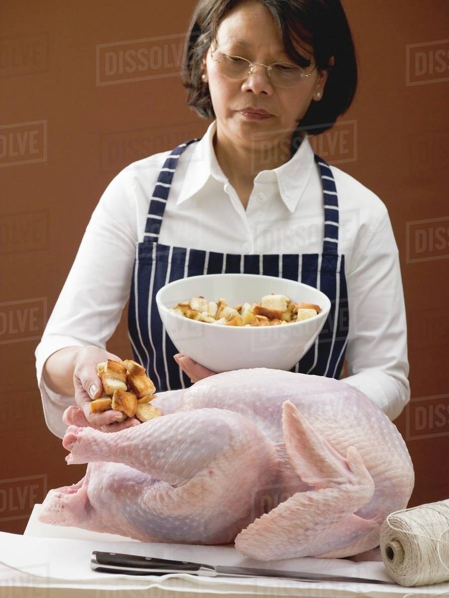 Woman stuffing turkey with bread cubes - Royalty-free Stock Photo ...
