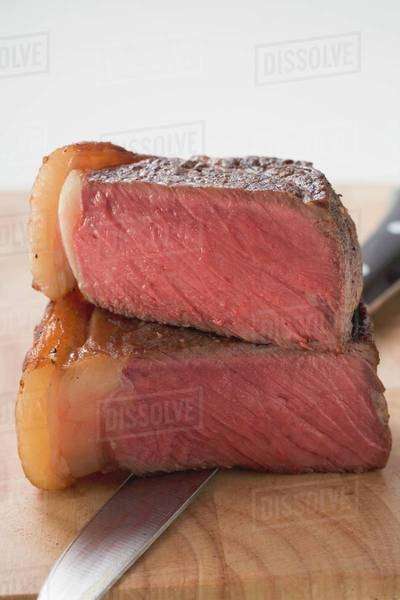 Beef steak with fatty edge, cut in two - Royalty-free Stock Photo ...