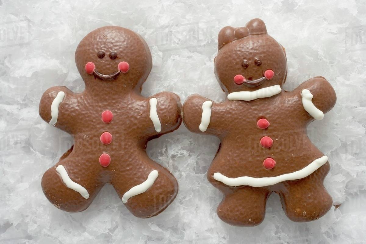 Two Christmassy chocolate-coated gingerbread people in snow - Royalty ...
